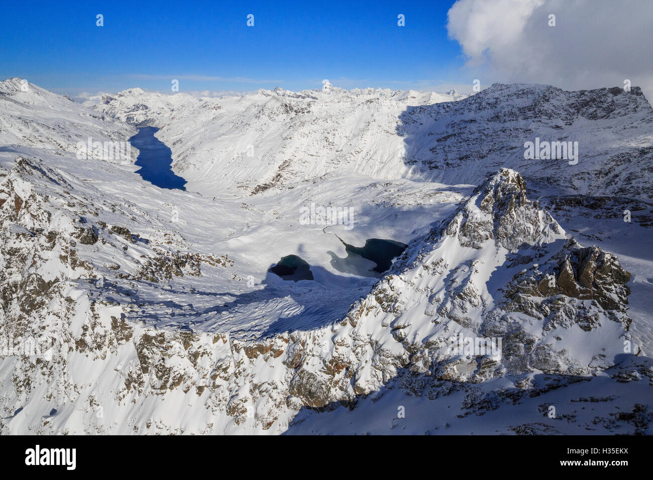 Aerial view of snowy Peak Peloso surrounded by Lago di Lei, Val di Lei ...