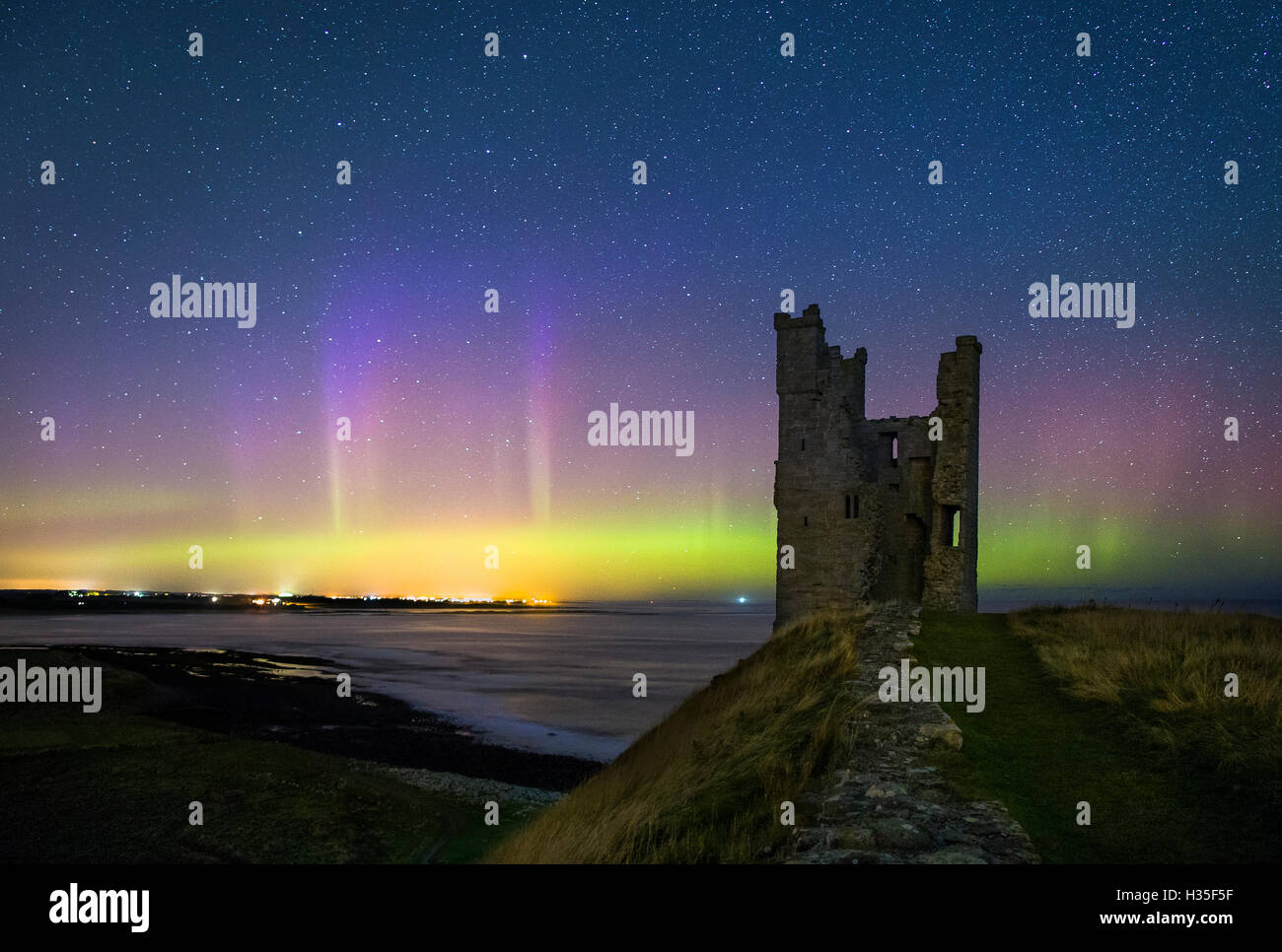 The Northern Lights at Dunstanburgh Castle, Northumberland Stock Photo ...