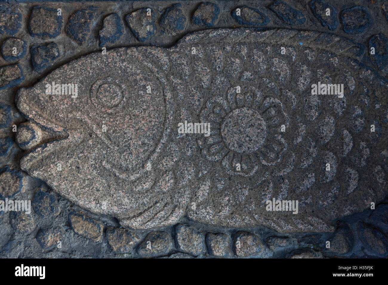 A detailed view shows a sculpted stone fish used as the entry step of a ...