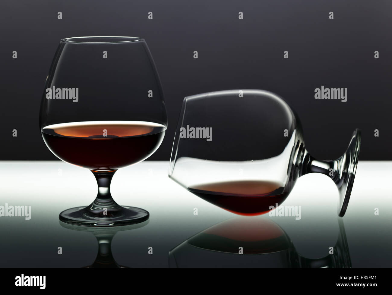 Two snifters of brandy on the reflective background Stock Photo - Alamy
