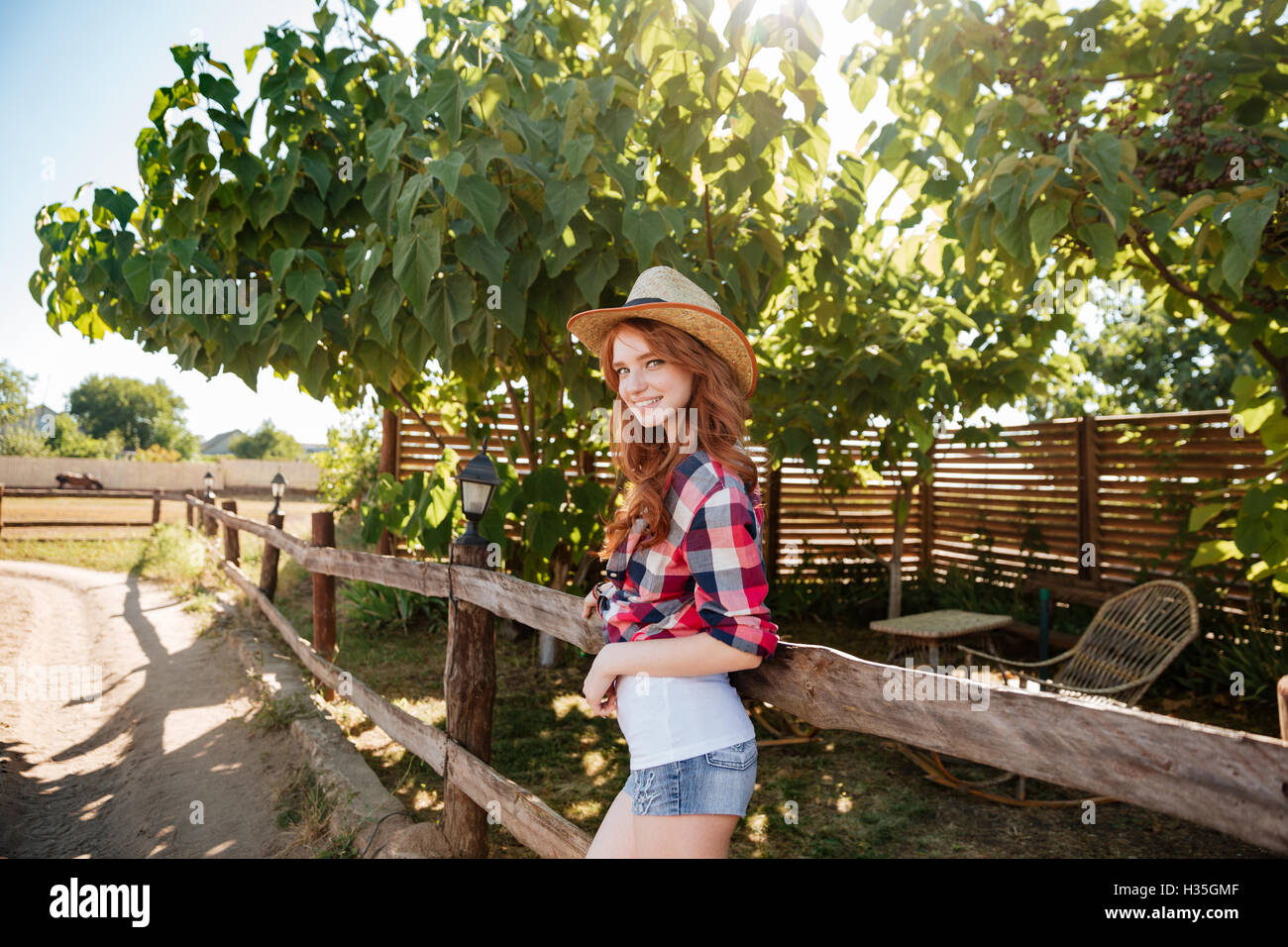 Cheerful pretty young woman cowgirl walking on farm Stock Photo - Alamy