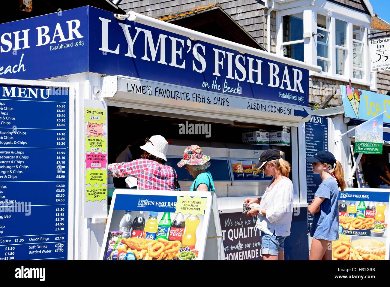 Tourists queuing to buy fish and chips from a beachfront chip shop ...