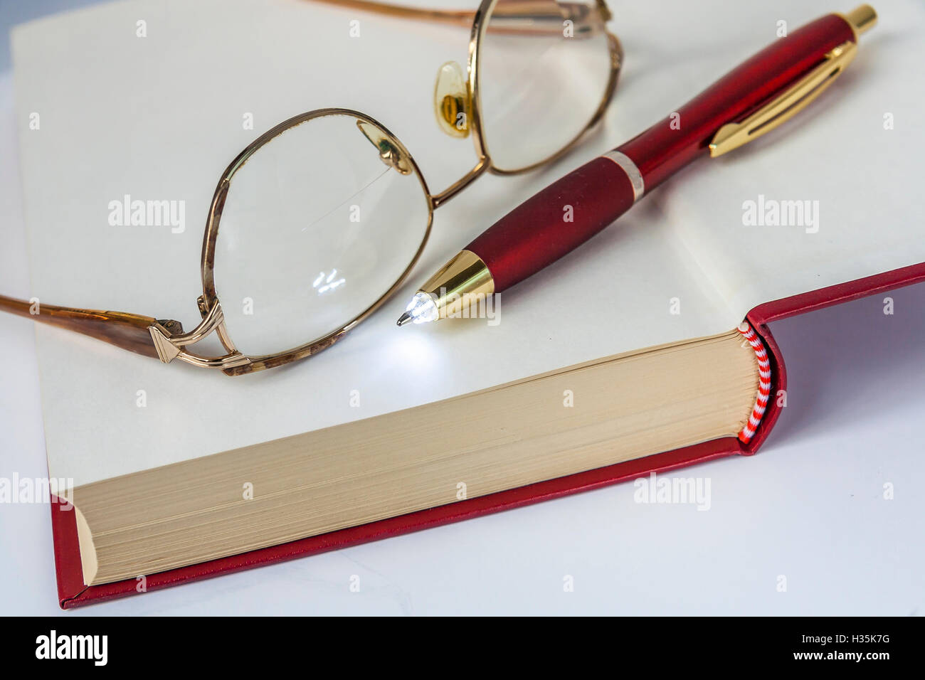 Reading Glasses And LED Light Pen Lying On The Open Book Stock Photo ...