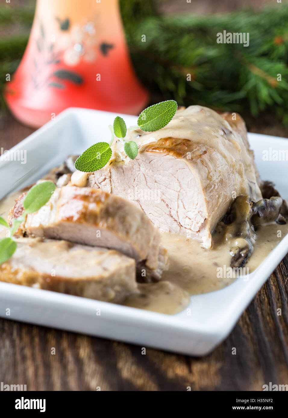 Delicious roast pork fillet with mushroom sauce on a white plate for ...