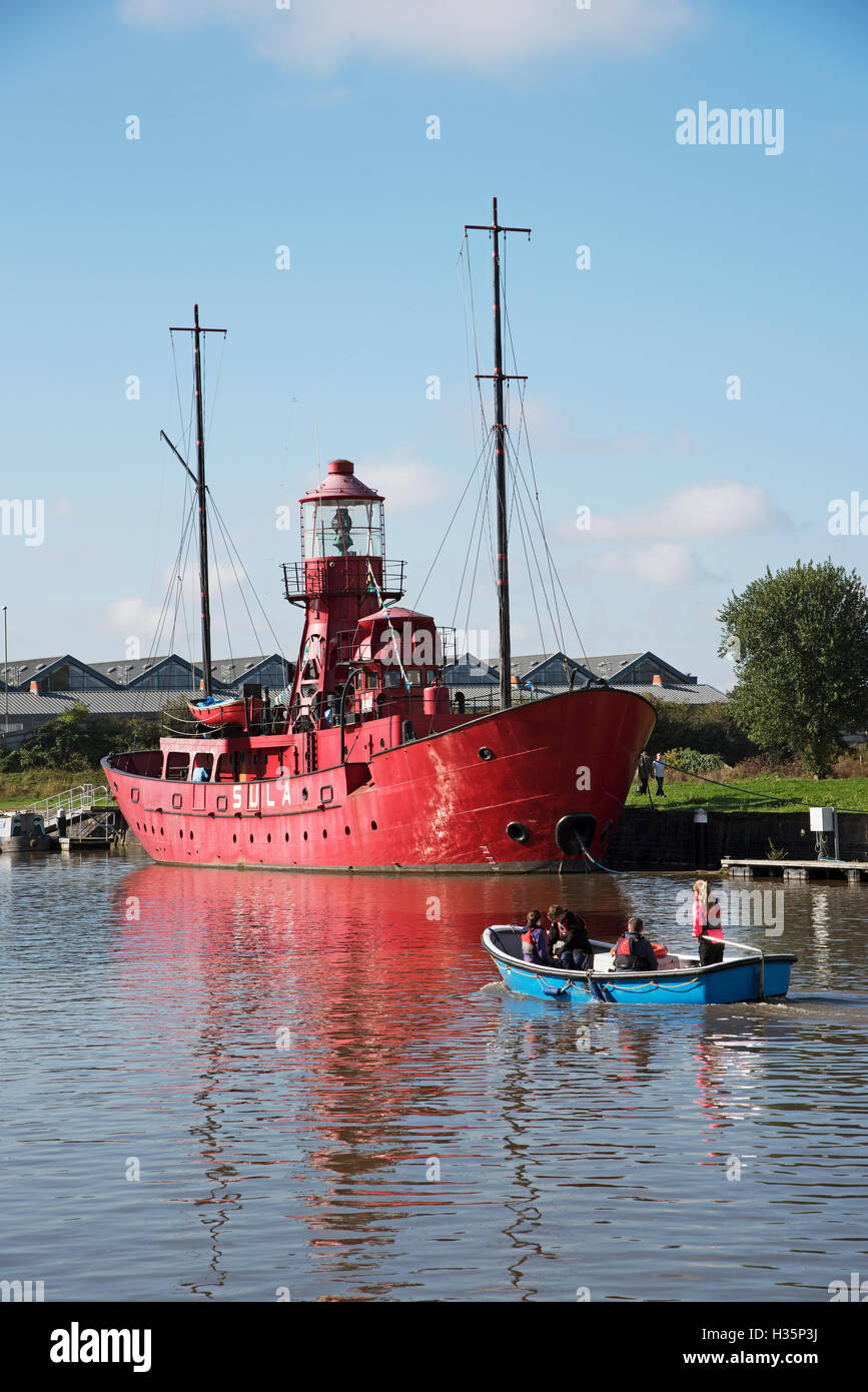 Sea cadets in training boat pass the old lightship Sula in Gloucester ...