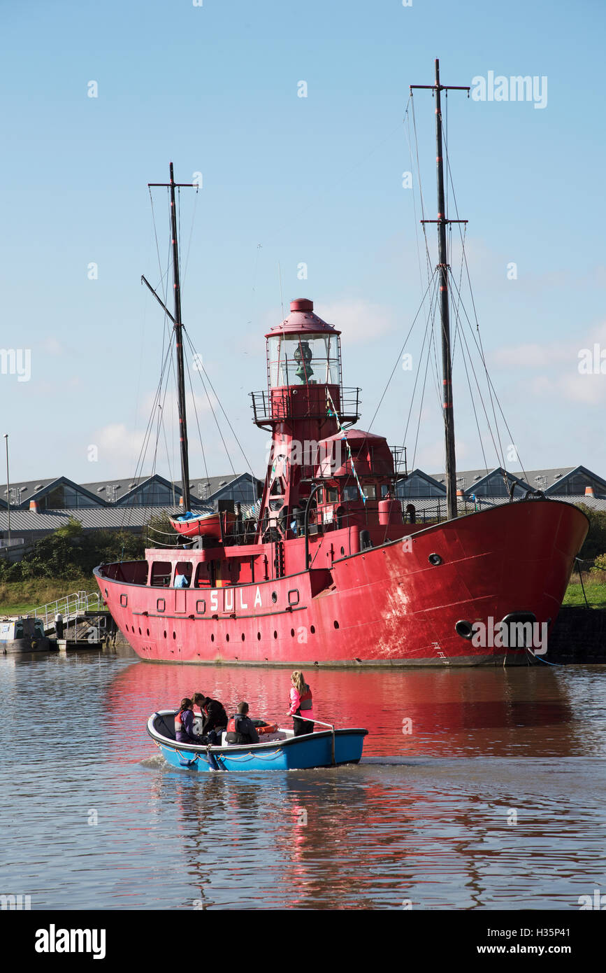 Sea cadets in training boat pass the old lightship Sula in Gloucester ...