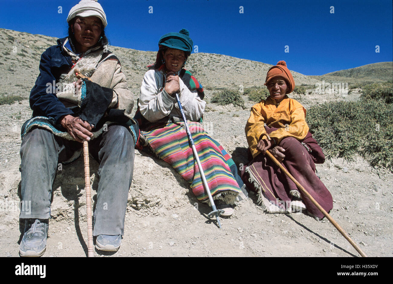 Three Tibetan pilgrims taking it easy after having just finished ...