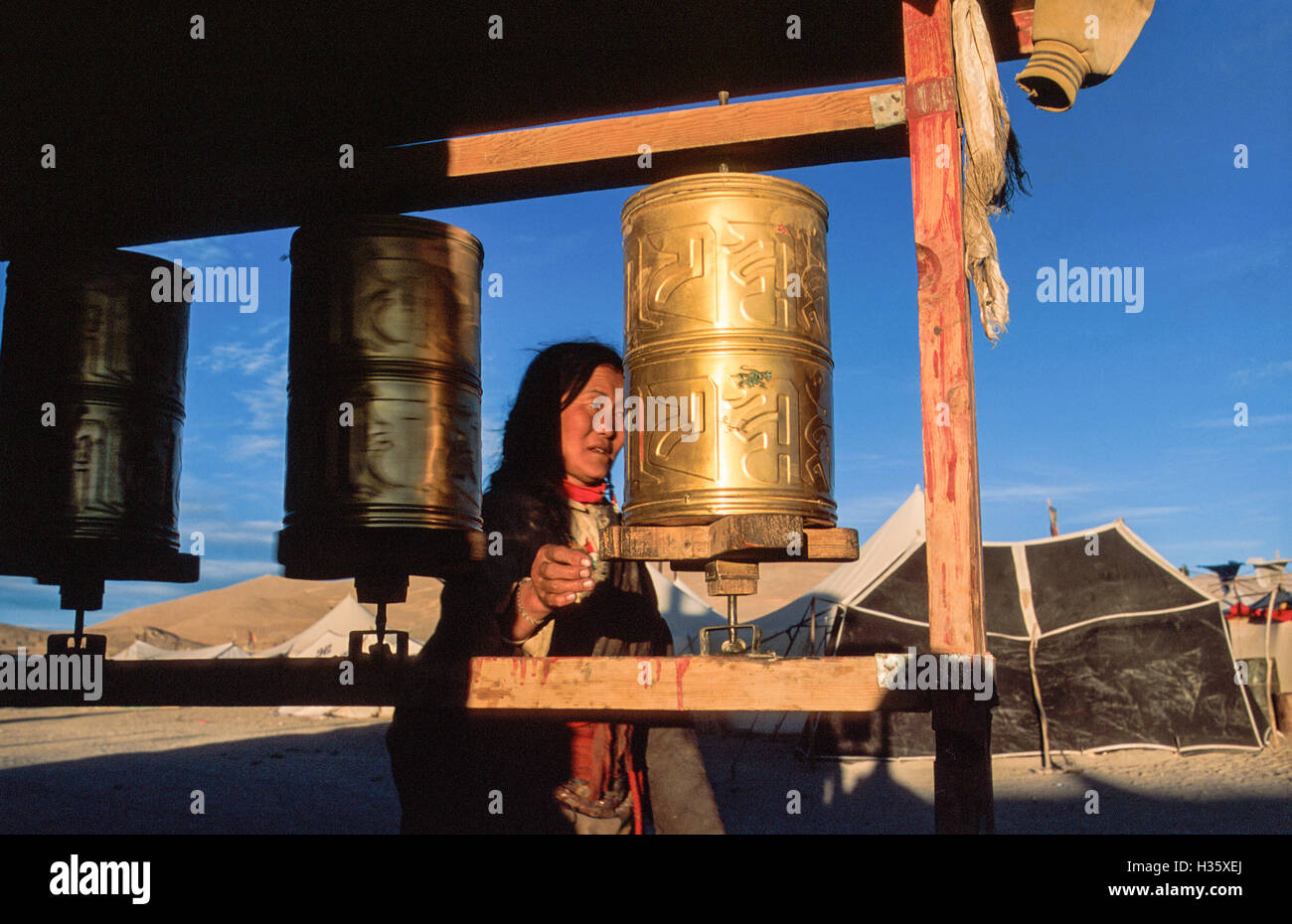 Tibetan woman circumambulating clockwise around a Buddhist chorten and ...
