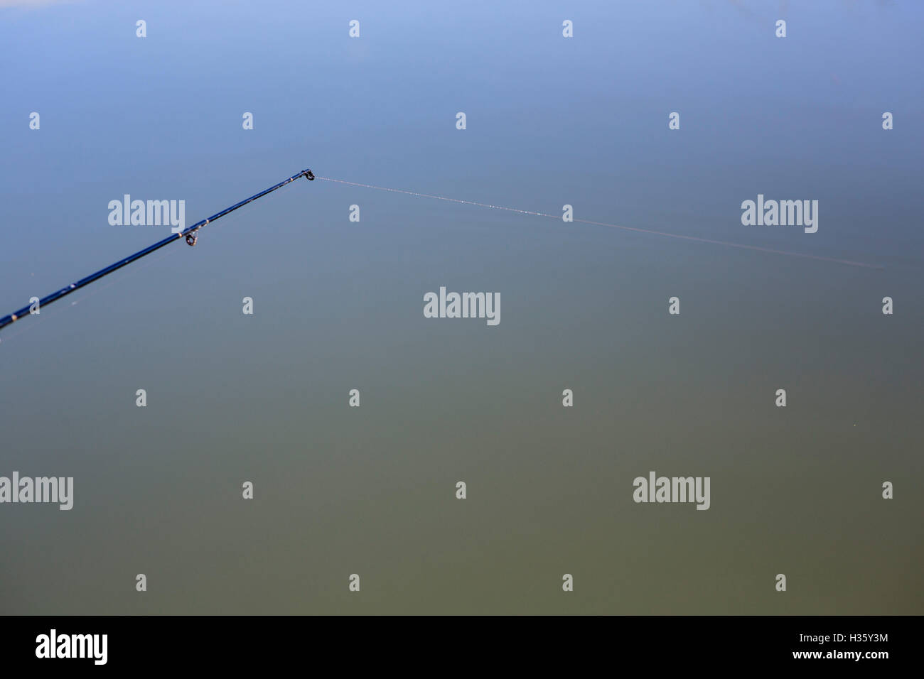 A fishing rod and line seen across a lake Stock Photo - Alamy