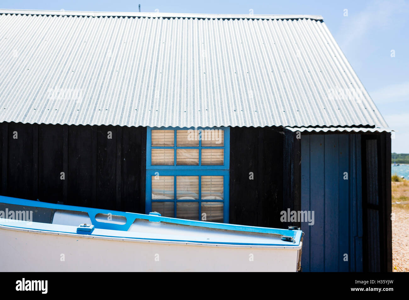 Small fishing boat outside an old shack on the beach Stock Photo - Alamy