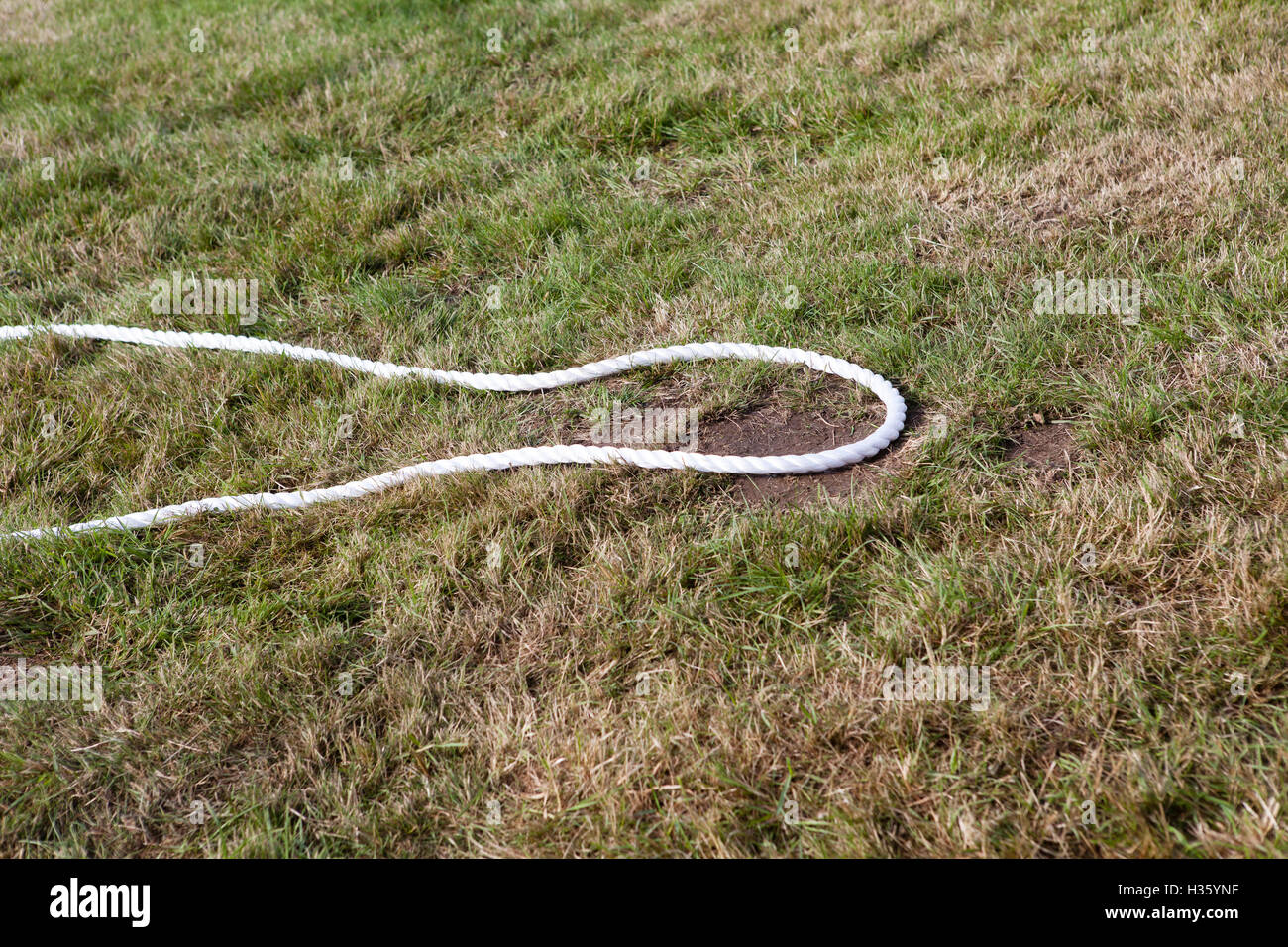 White rope boundary fence in a green grass field Stock Photo - Alamy