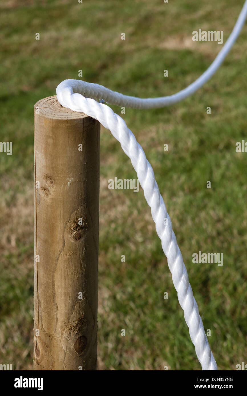 White rope boundary fence in a green grass field Stock Photo - Alamy