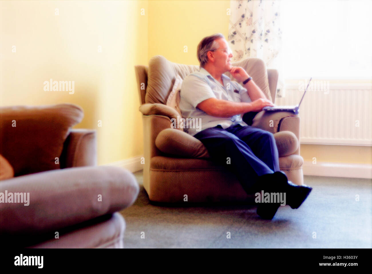 An old man grandfather or retired person using a laptop computer in his ...