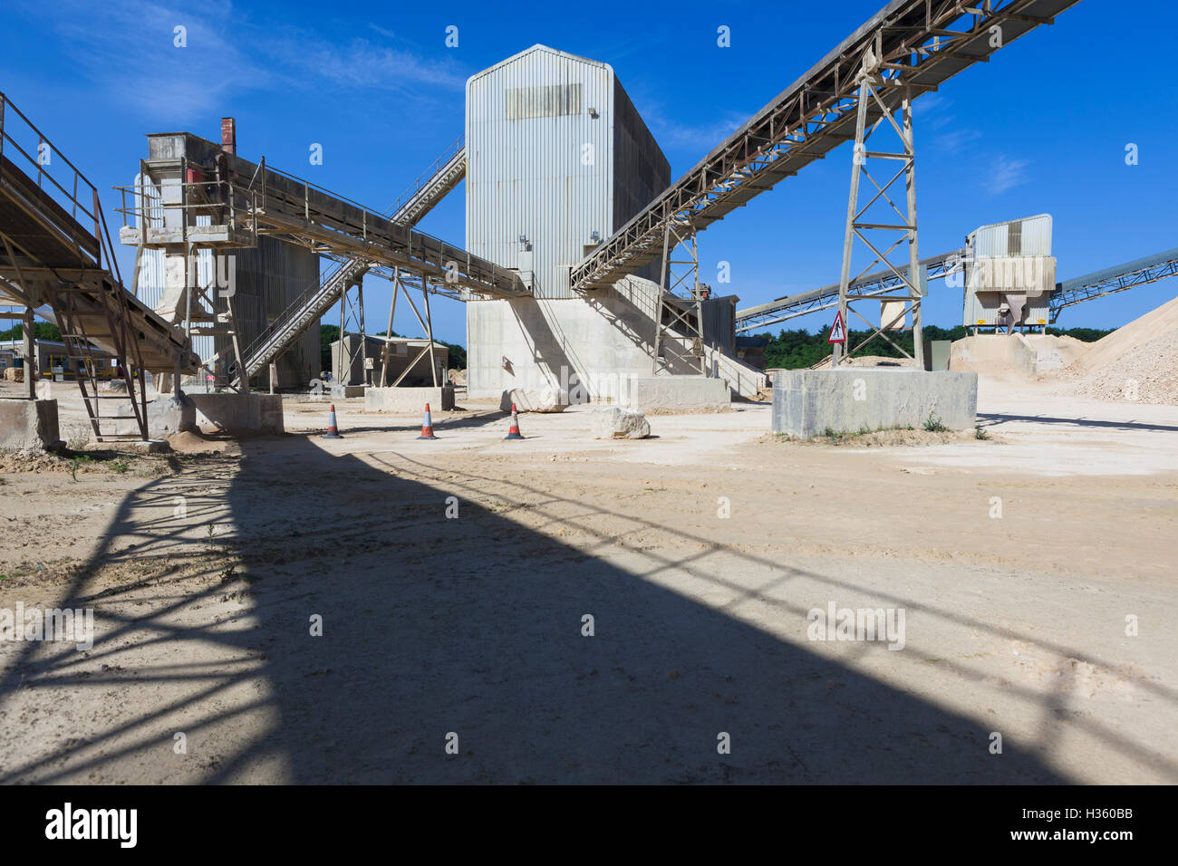 A large open cast quarry with old tin buildings, manufacturing ...