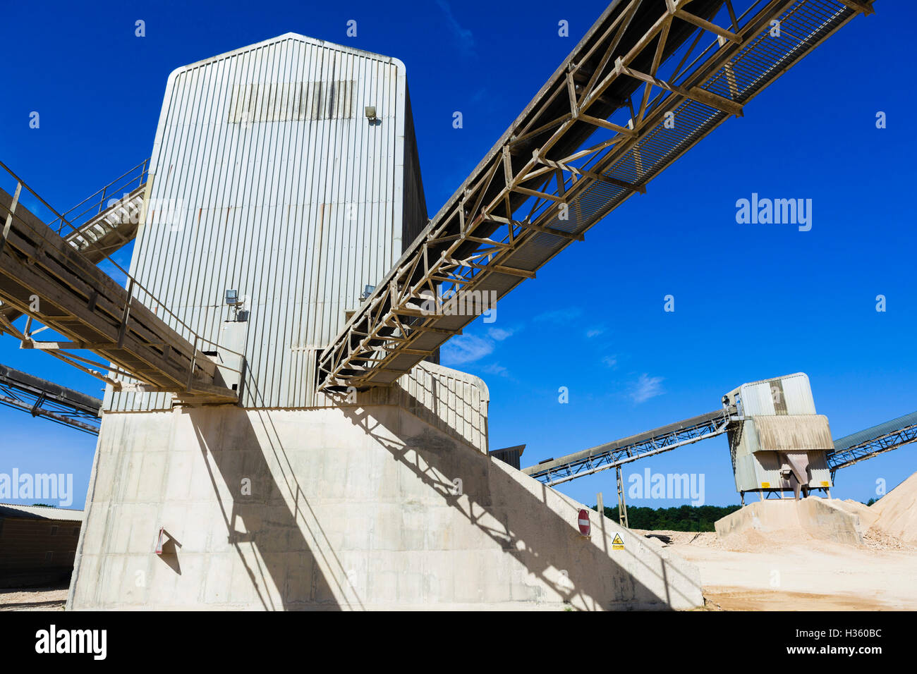 A large open cast quarry with old tin buildings, manufacturing ...