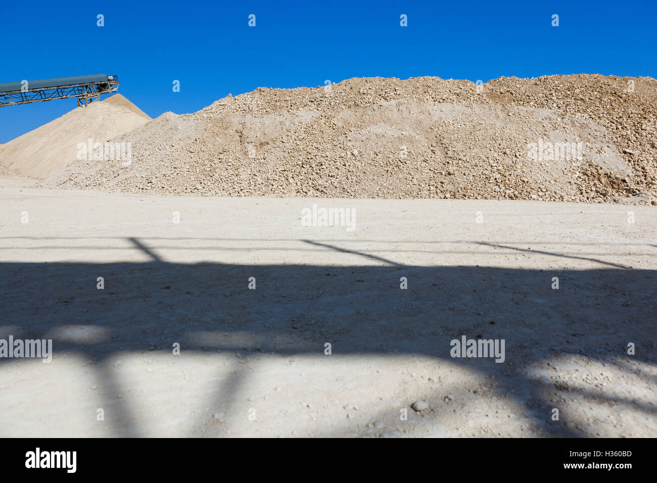 A large open cast quarry with old tin buildings, manufacturing ...