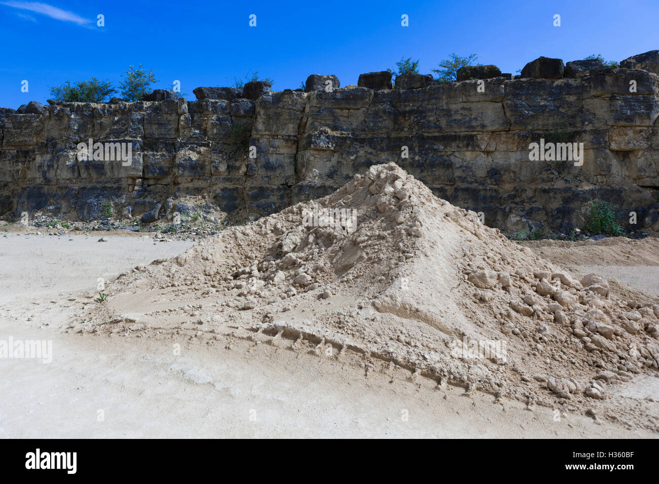A large open cast quarry with old tin buildings, manufacturing ...
