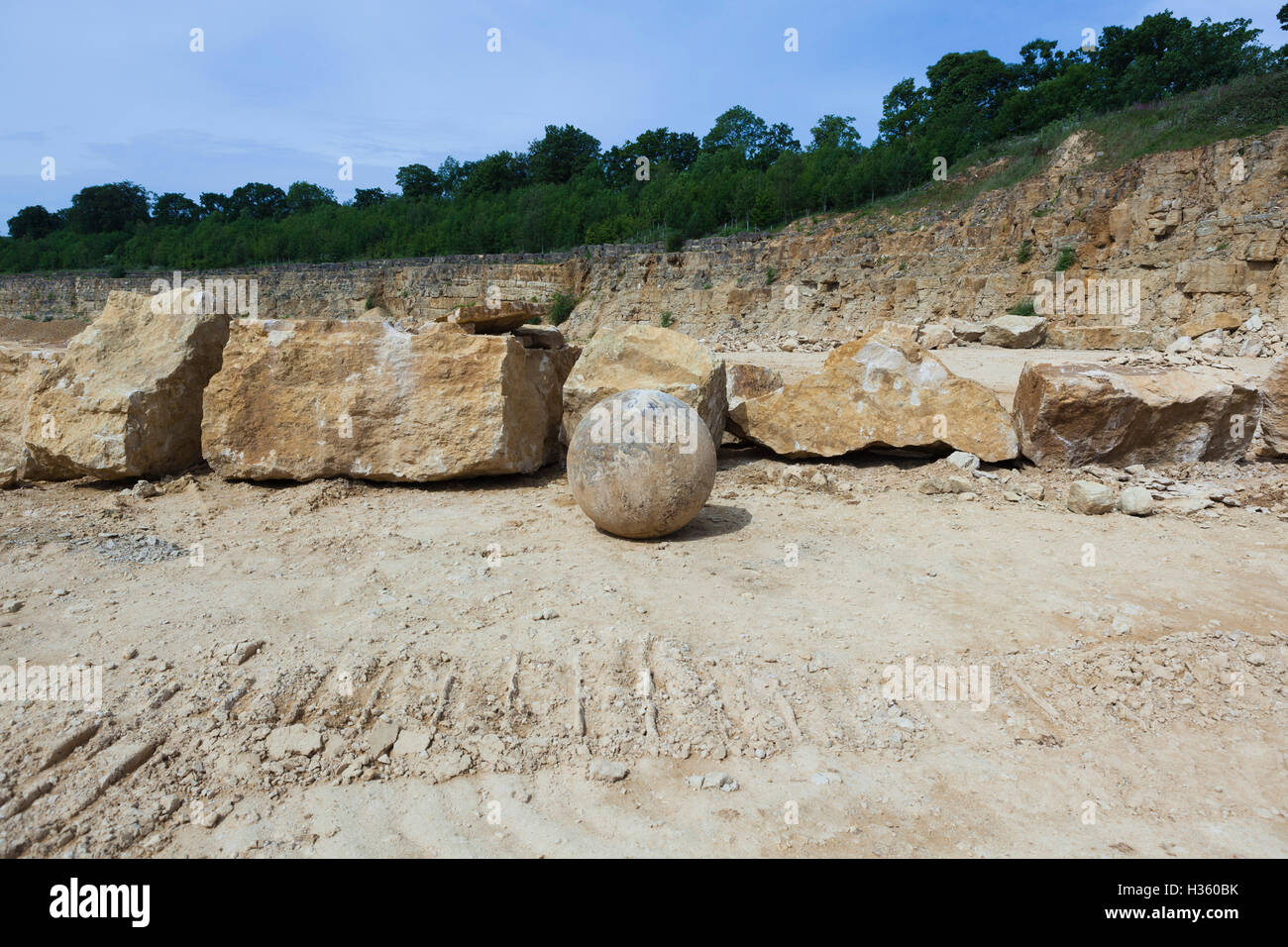 A large open cast quarry with old tin buildings, manufacturing ...