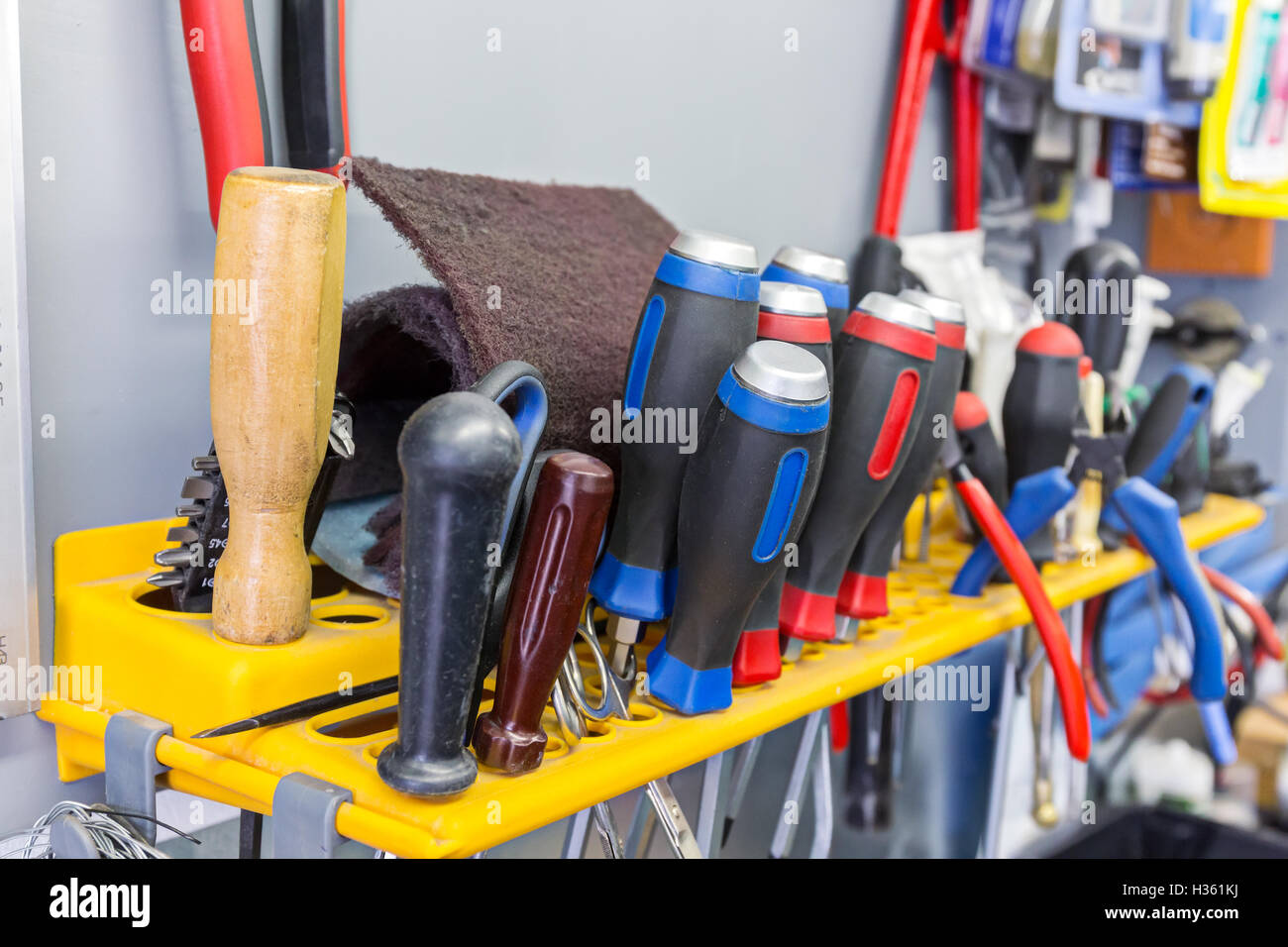 Set of work tools hanging on grey background Stock Photo - Alamy