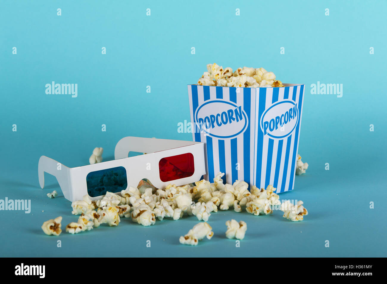 Bucket of popcorn against a blue background Stock Photo - Alamy