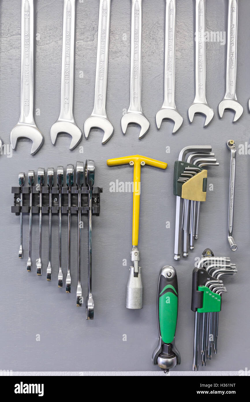 Assortment of hand tools hanging on grey wall Stock Photo - Alamy