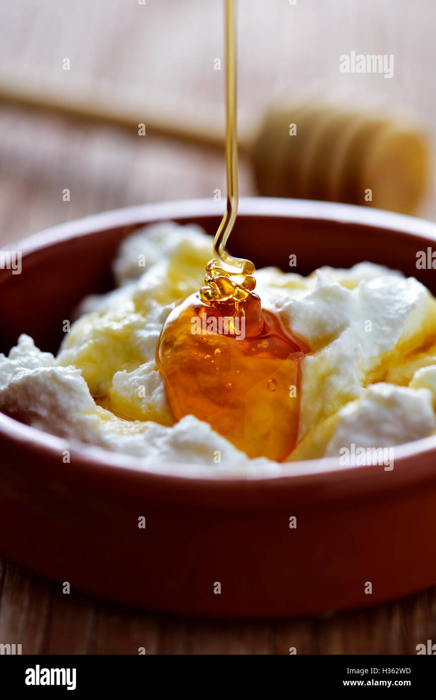 closeup of a earthenware bowl with mel i mato, a typical dessert in ...