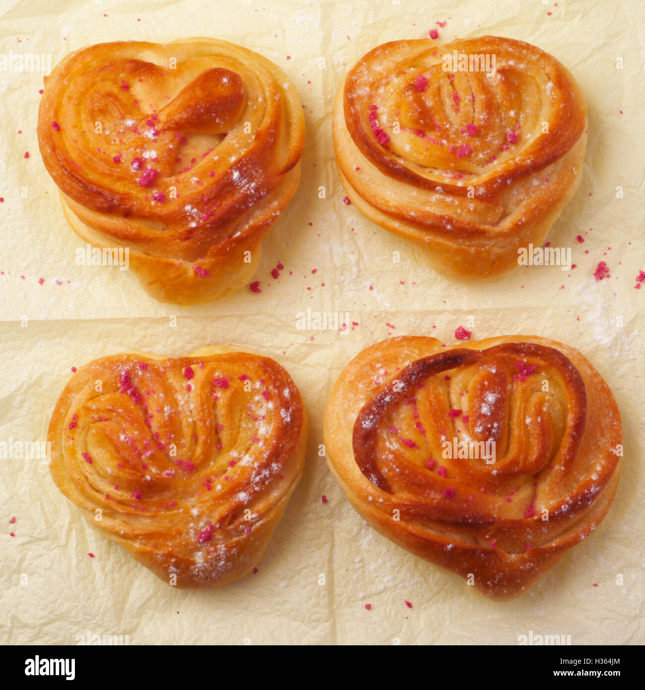 Four heart shaped buns on the yellow background Stock Photo - Alamy