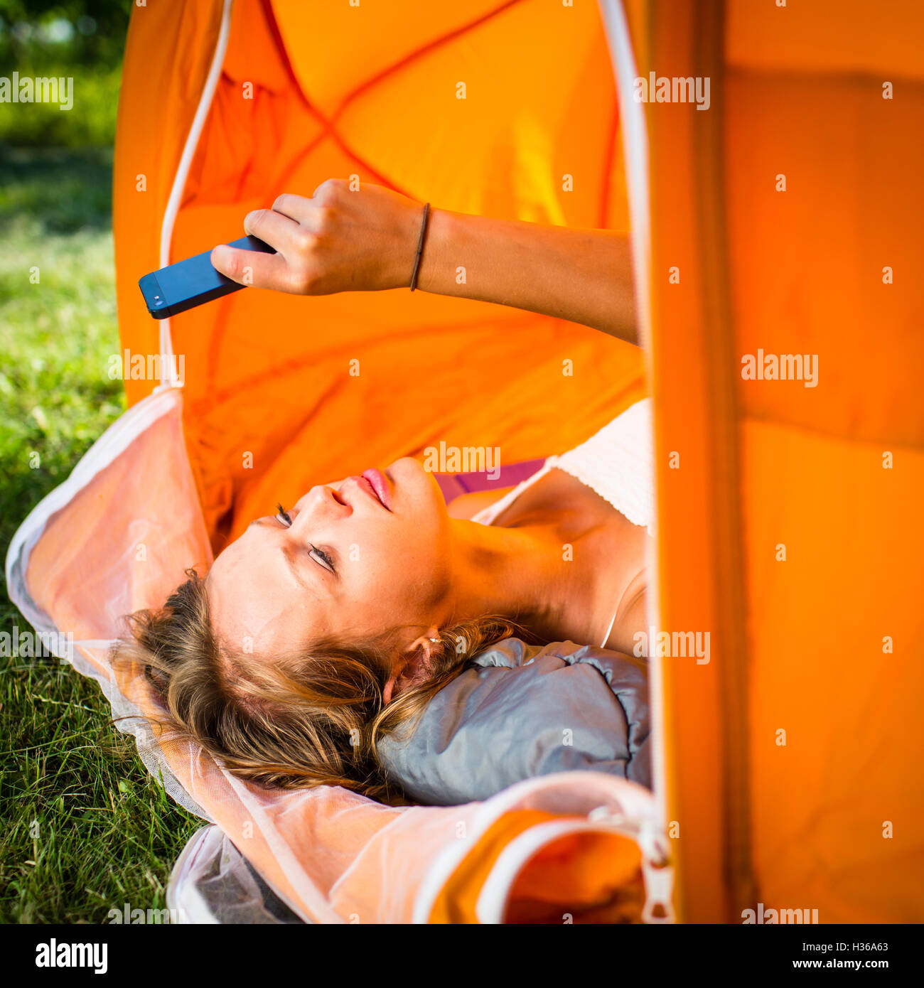 Pretty, young woman camping outdoors, lying in the tent Stock Photo - Alamy
