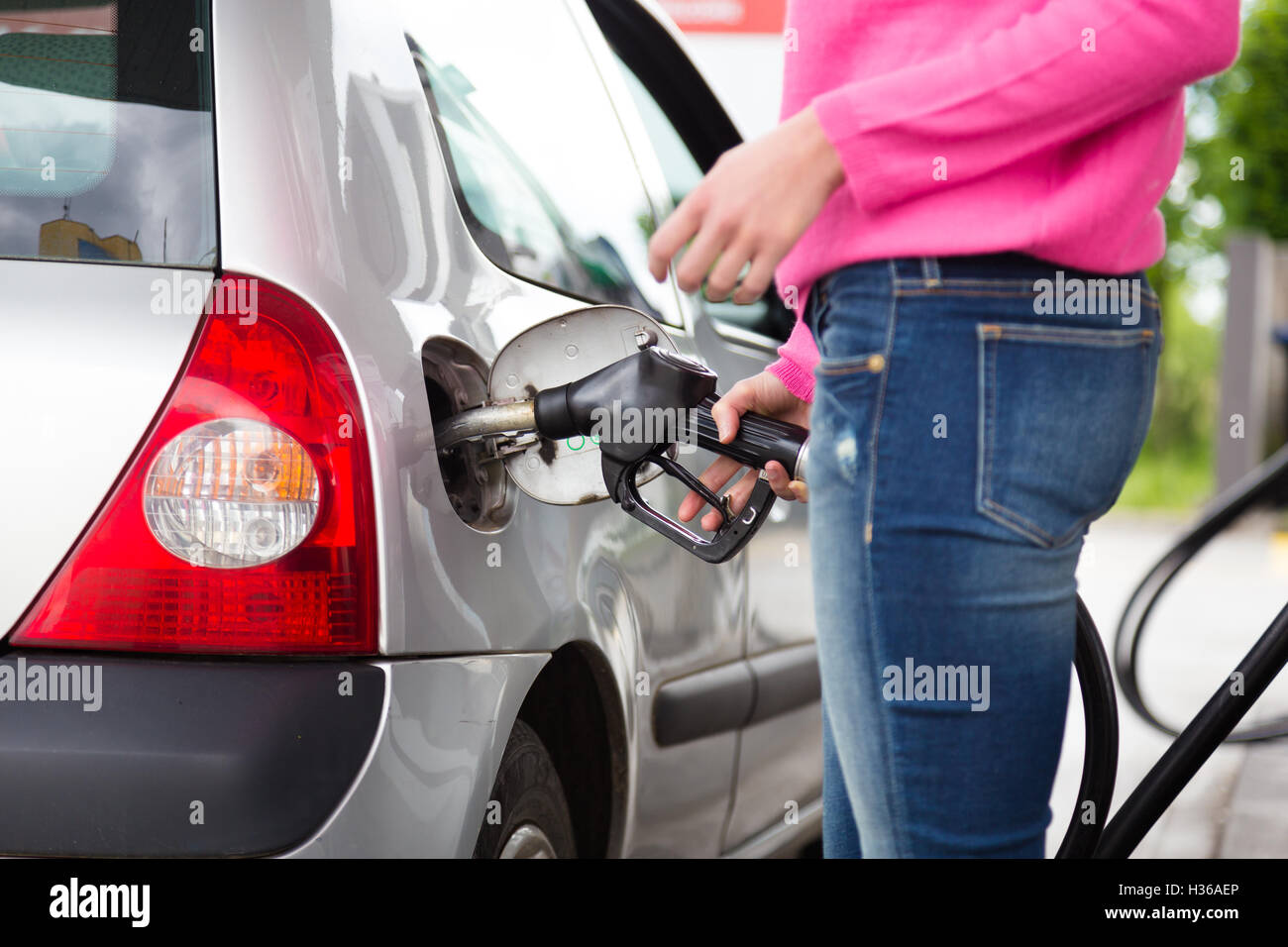 Lady pumping gasoline fuel in car at gas station Stock Photo - Alamy