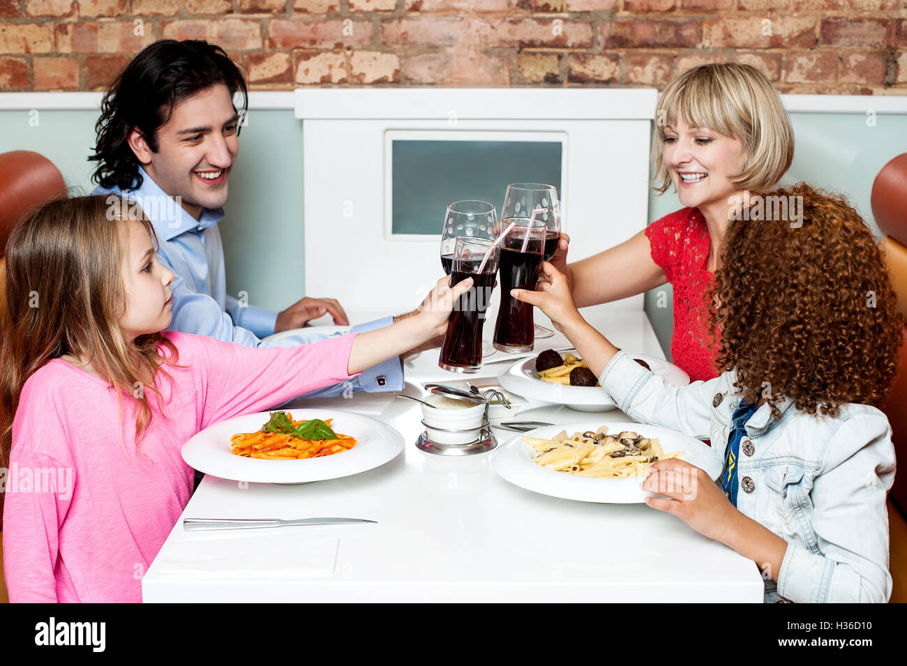 Cheerful family of four celebrating, Cheers! Stock Photo - Alamy