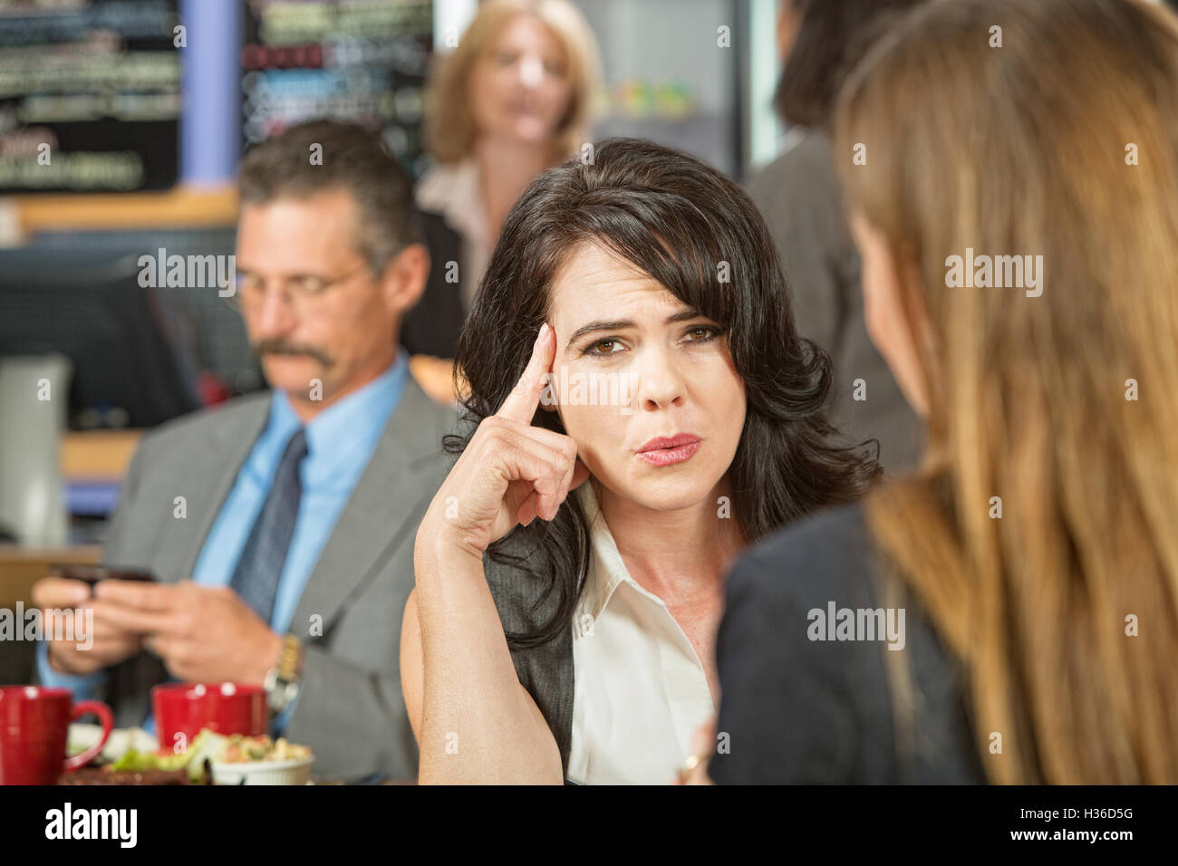 Woman with Finger on Head Stock Photo - Alamy