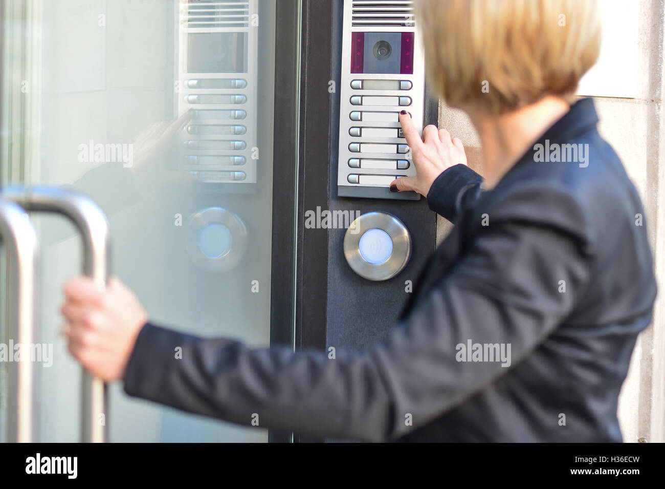 Woman pushing a intercom button Stock Photo - Alamy