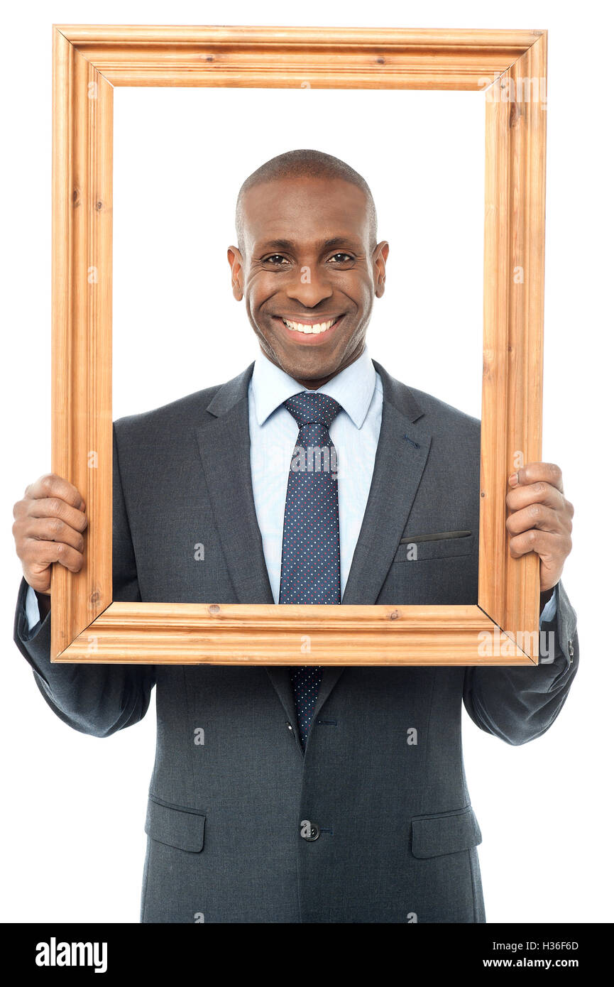 Smiling businessman looking through picture frame Stock Photo - Alamy