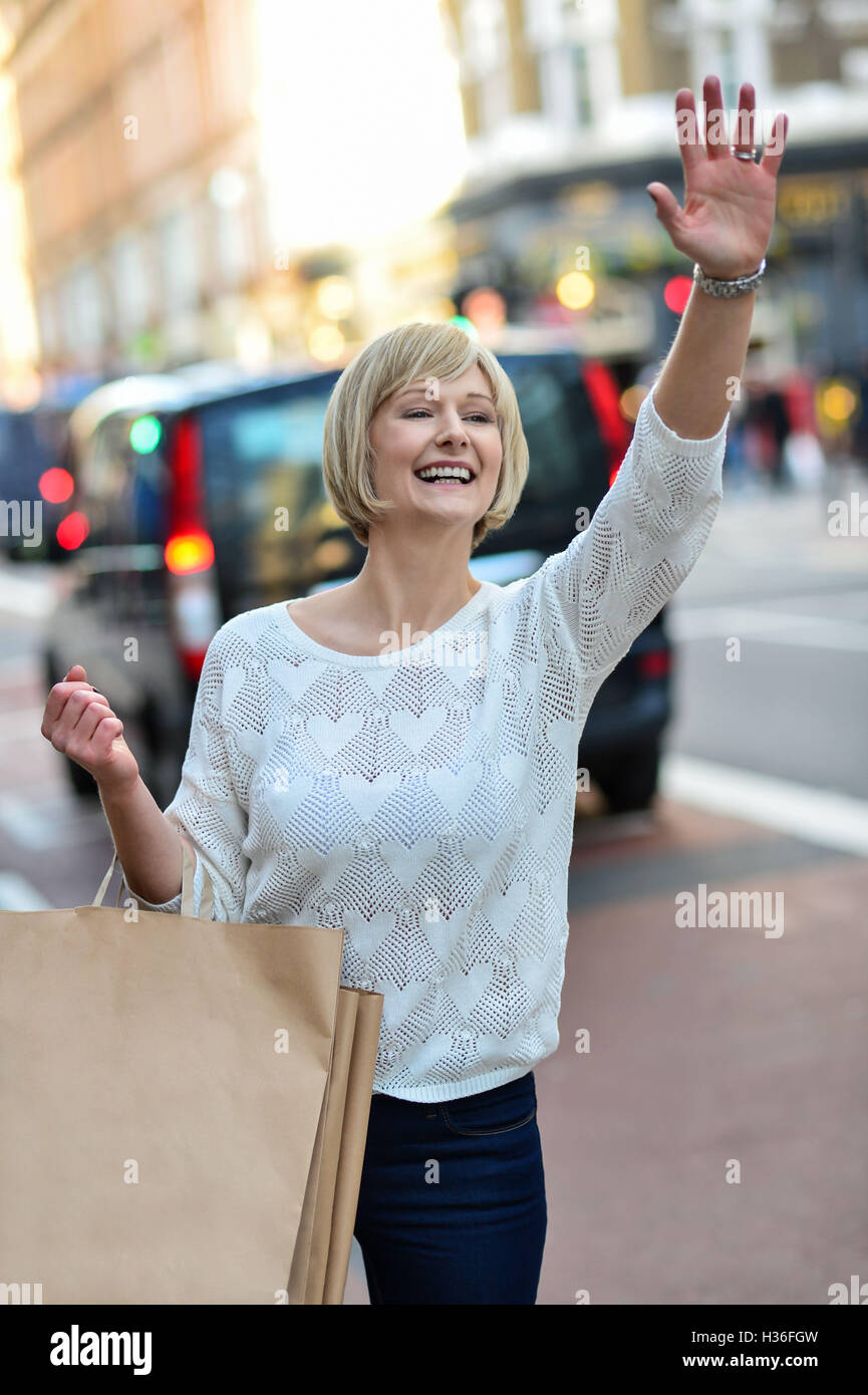 Casual woman hailing a taxi cab Stock Photo - Alamy
