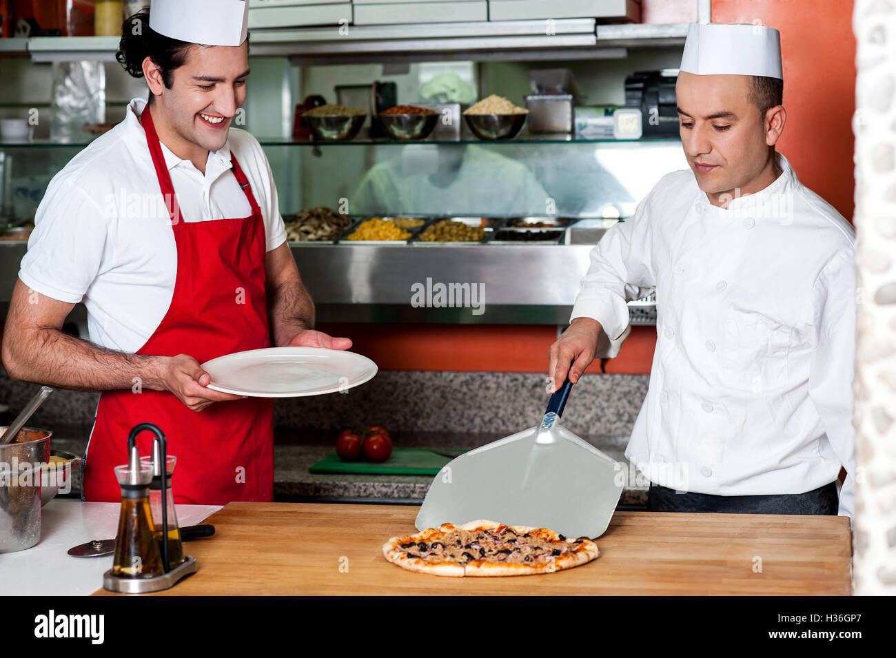 Chef picking pizza, ready to be served Stock Photo - Alamy