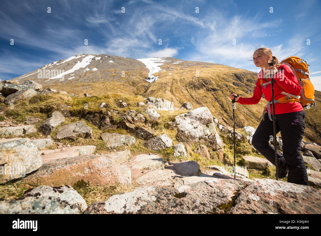 Pretty, young female hiker going uphill Stock Photo - Alamy