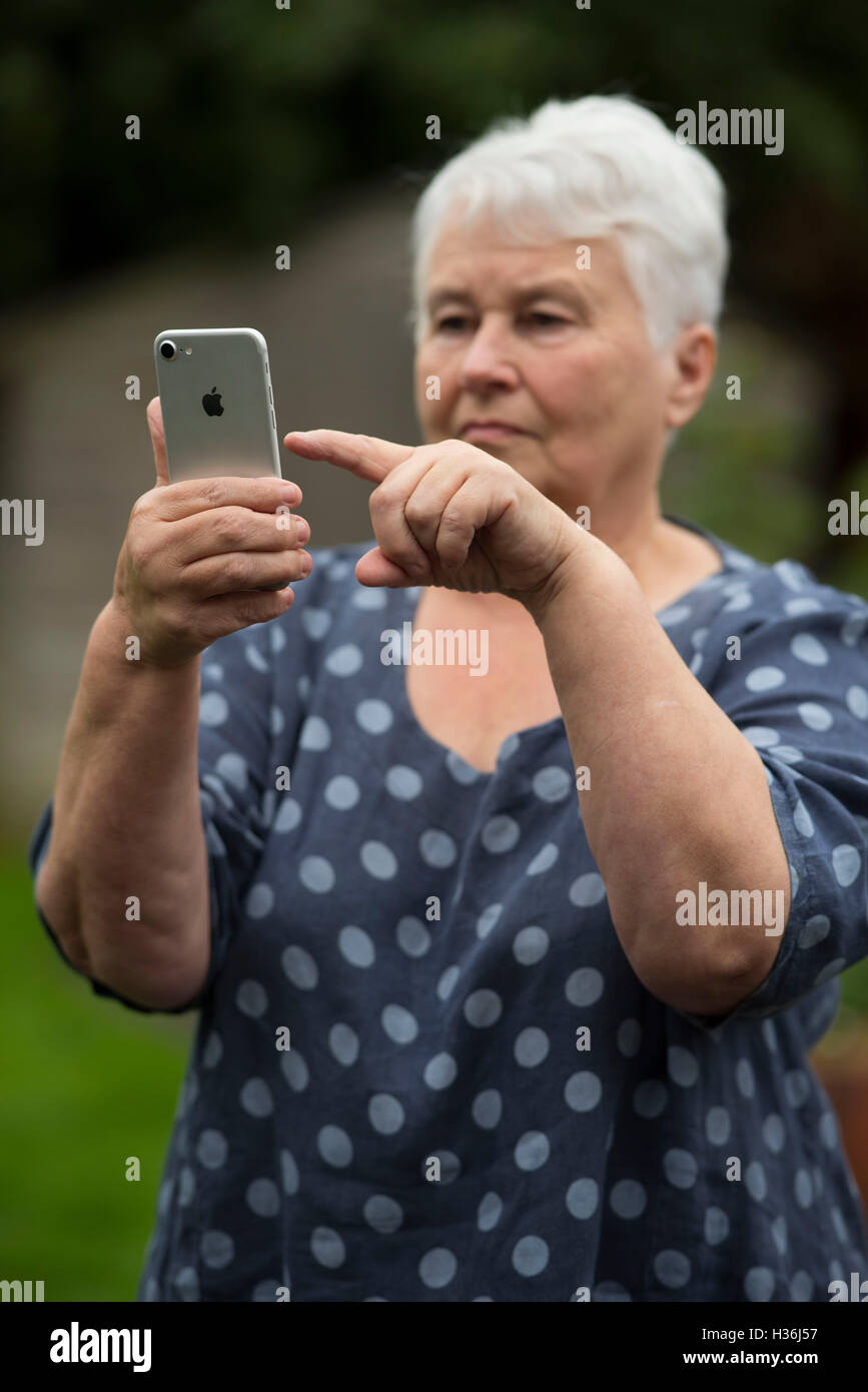 An elderly woman using an iPhone mobile phone Stock Photo - Alamy