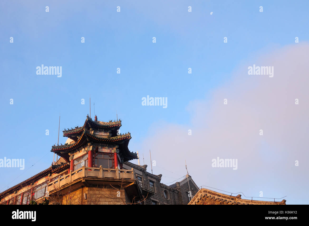 A waning moon setting over a Chinese building on the summit of Taishan ...