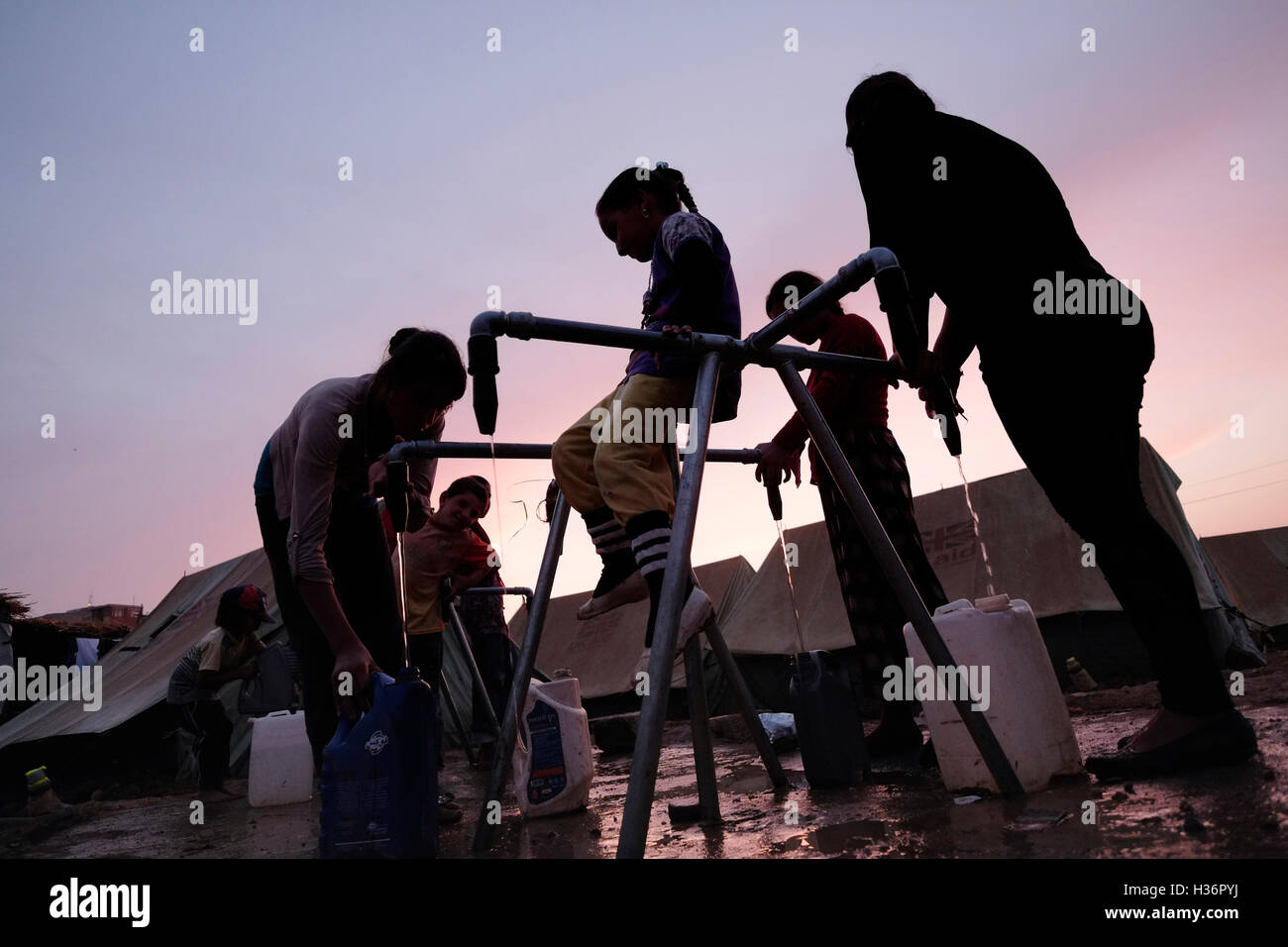 Yazidi Women Filling Drinking Water In Plastic Jerrycans At A Refugee