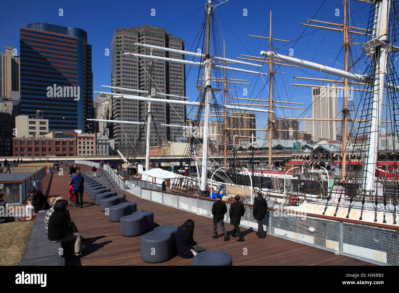 Visitors on the boardwalk of South Street Seaport with tall ships ...