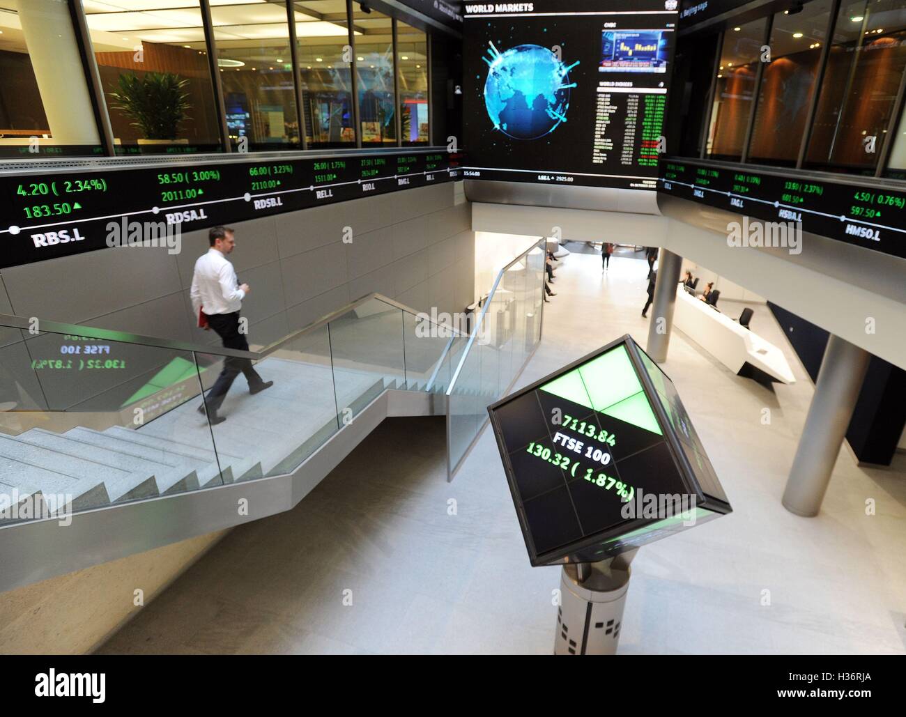 Electronic ticker tape shows the FTSE 100 (in green) inside the London ...