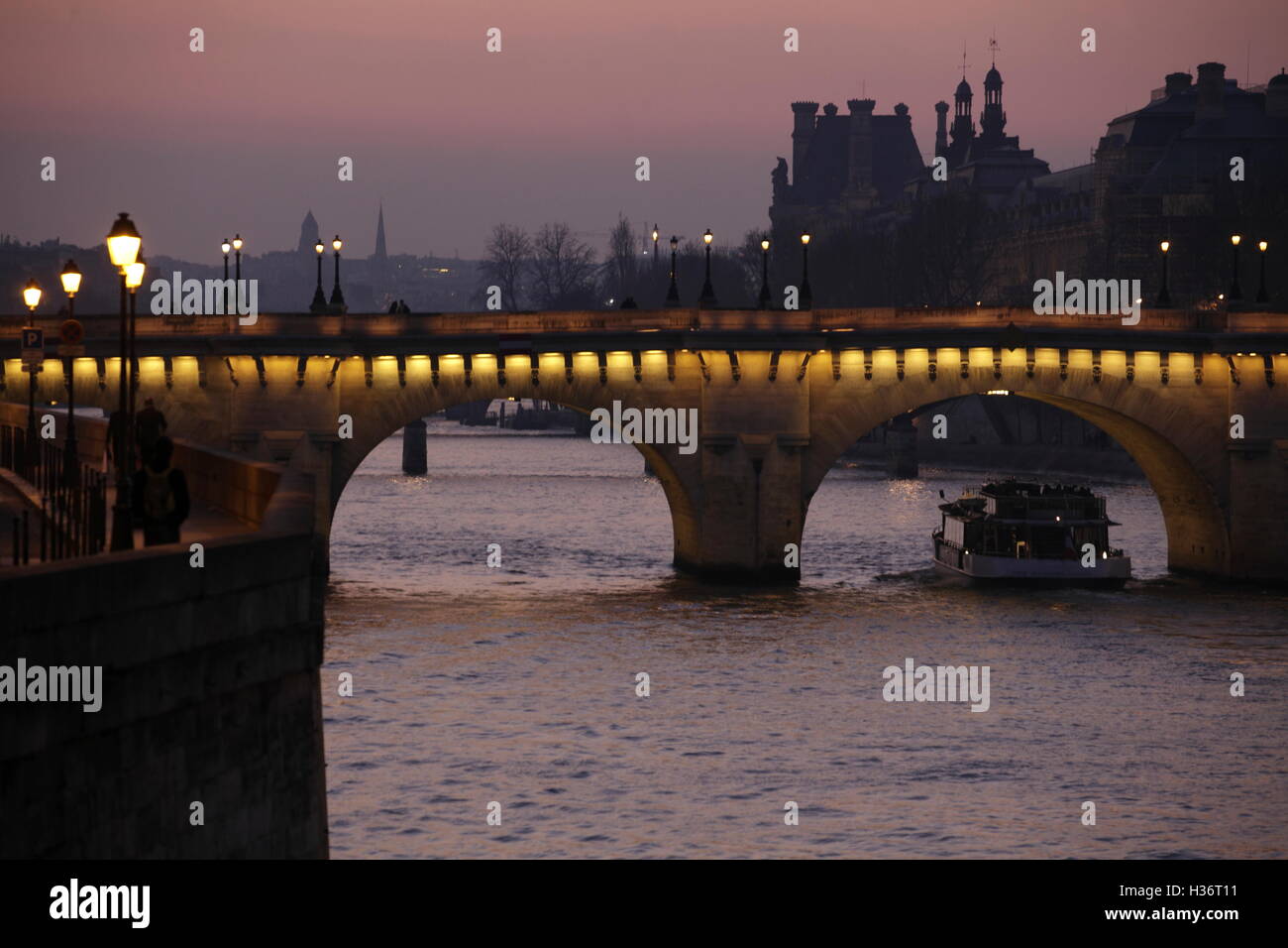 Pont Neuf Bridge over River Seine at night with a tour boat in ...