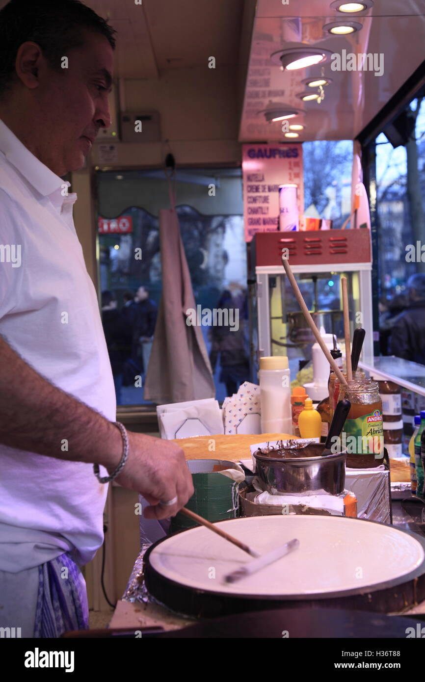 A street vendor making crepe a French style of thin pancake in a stall ...