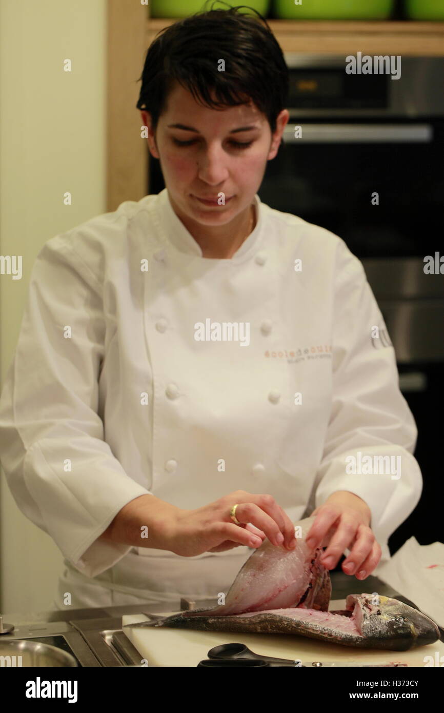 A Chef demonstrating the skill of fish cutting in the cooking class of ...