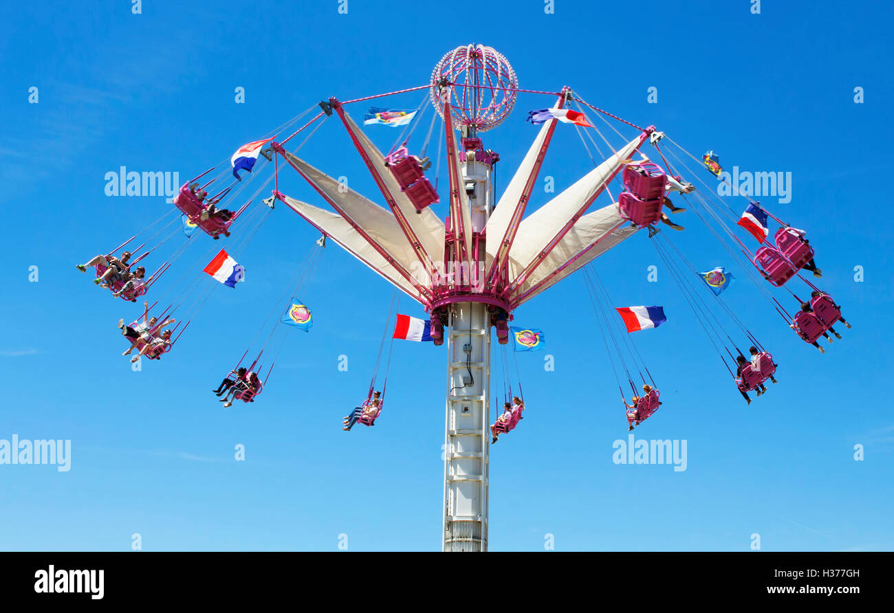 Bottom view of people riding carousel with French flags waving in Paris ...