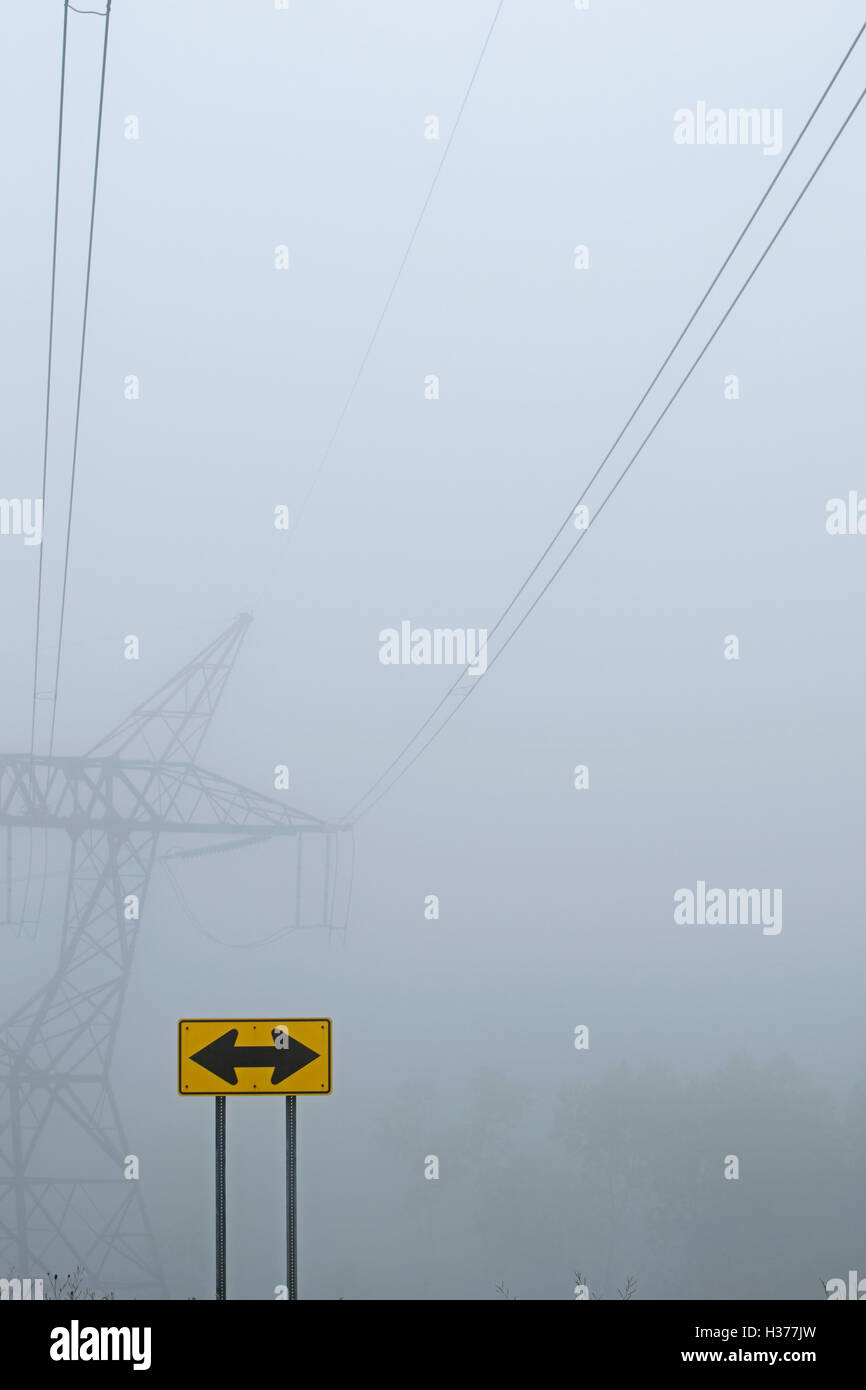 Yellow Directional Sign Near Powerlines in Fog Stock Photo - Alamy