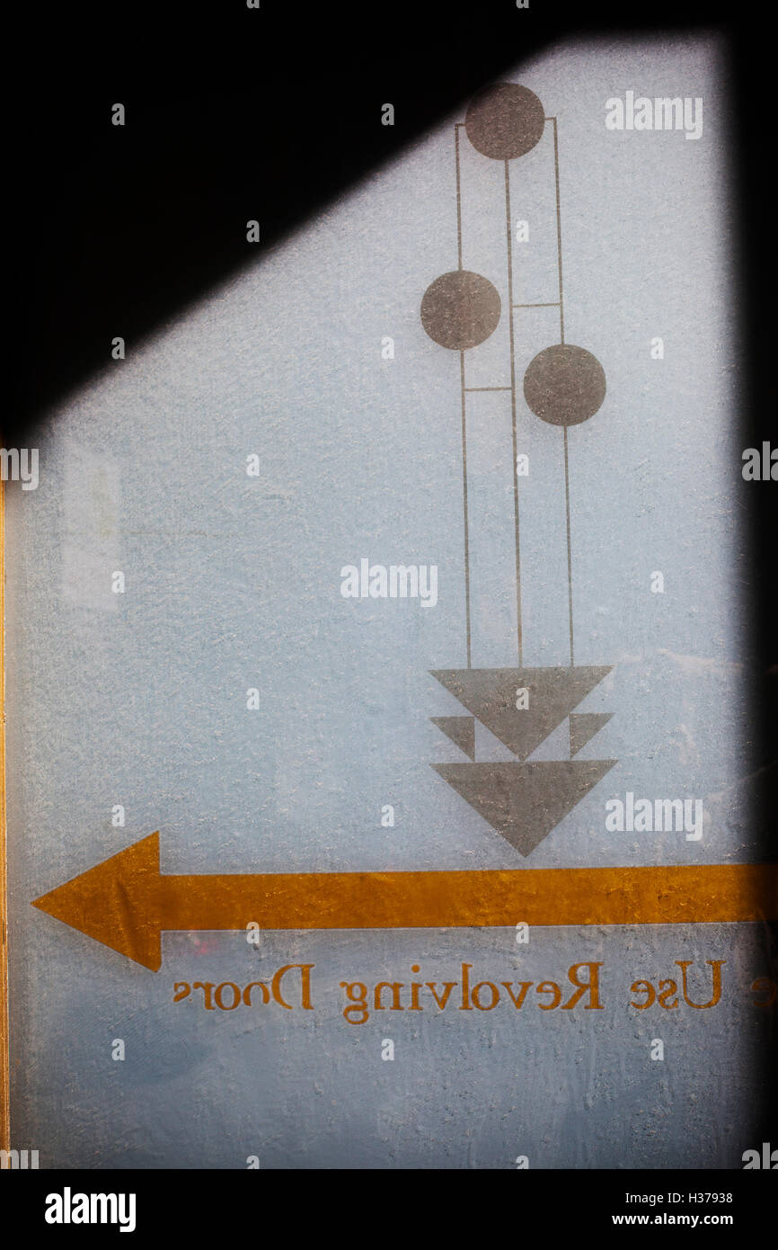 Art deco directional sign seen in reverse Stock Photo - Alamy