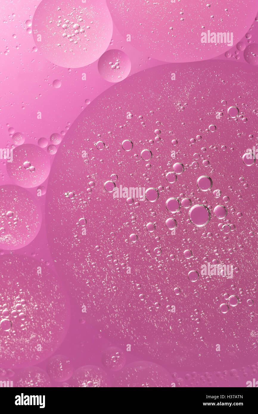 Abstract of oil droplet of various sizes. All is in a pink color hues ...