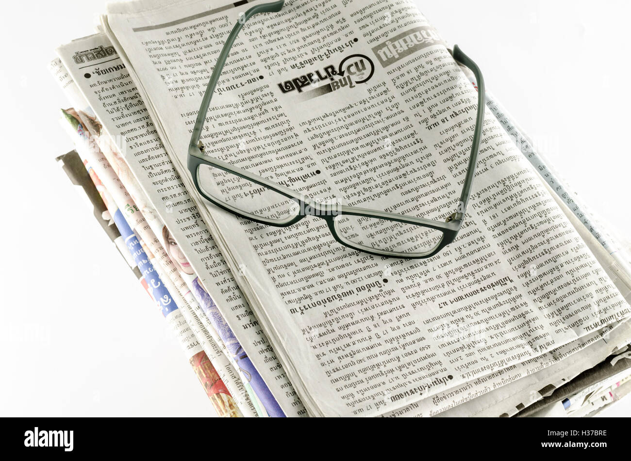 stack of newspaper with glasses Stock Photo - Alamy