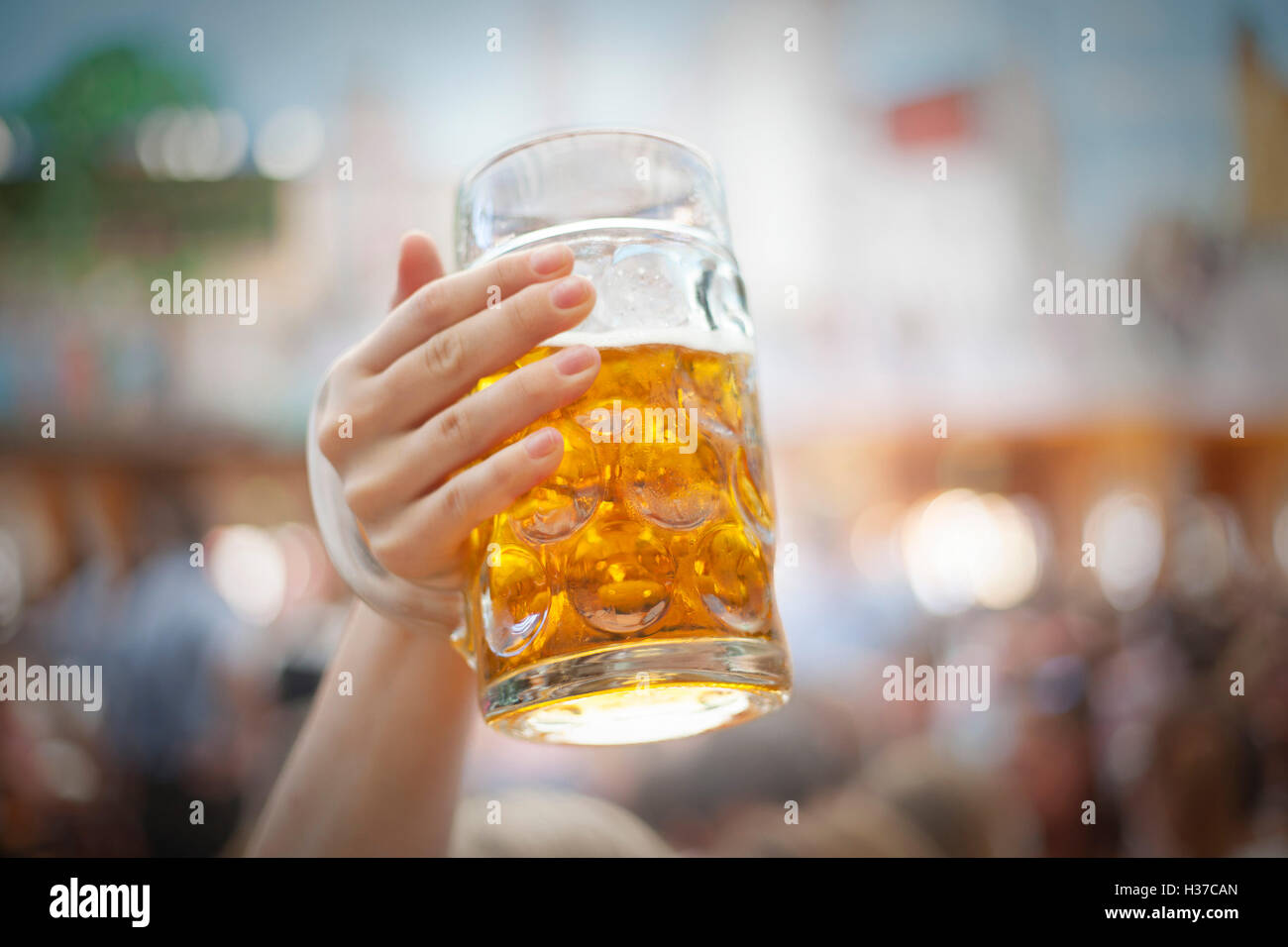 Raised beer mug toasting at Oktoberfest Stock Photo - Alamy